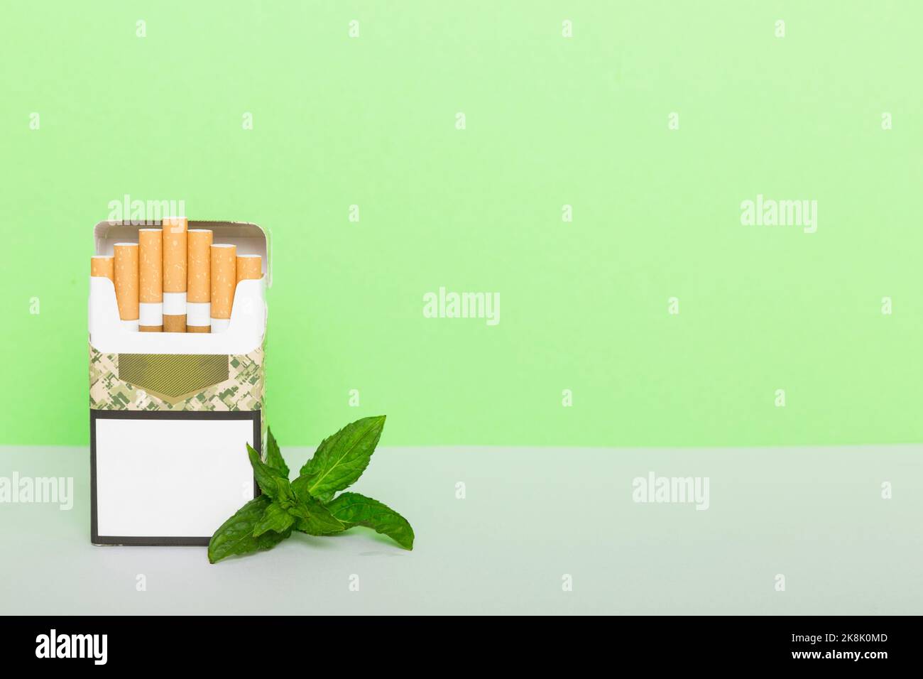 Pack of menthol cigarettes and fresh mint on colored table, Menthol ...