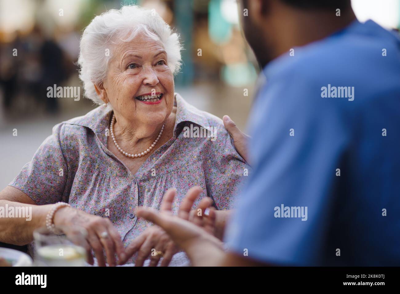 Caregiver talking with his client at cafe, having nice time together ...