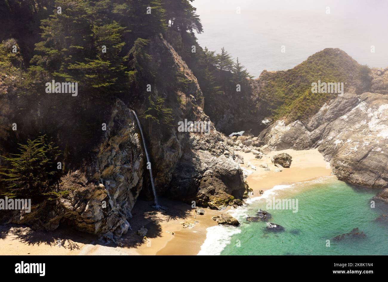 A Scenic view of blue seascape with green trees under sunny sky Stock ...