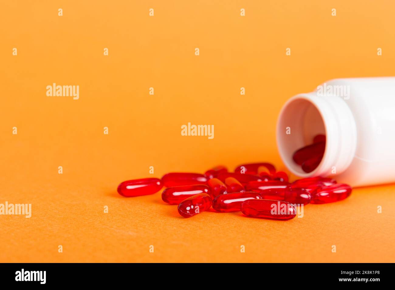 Red pills spilled around a pill bottle. Medicines and prescription ...