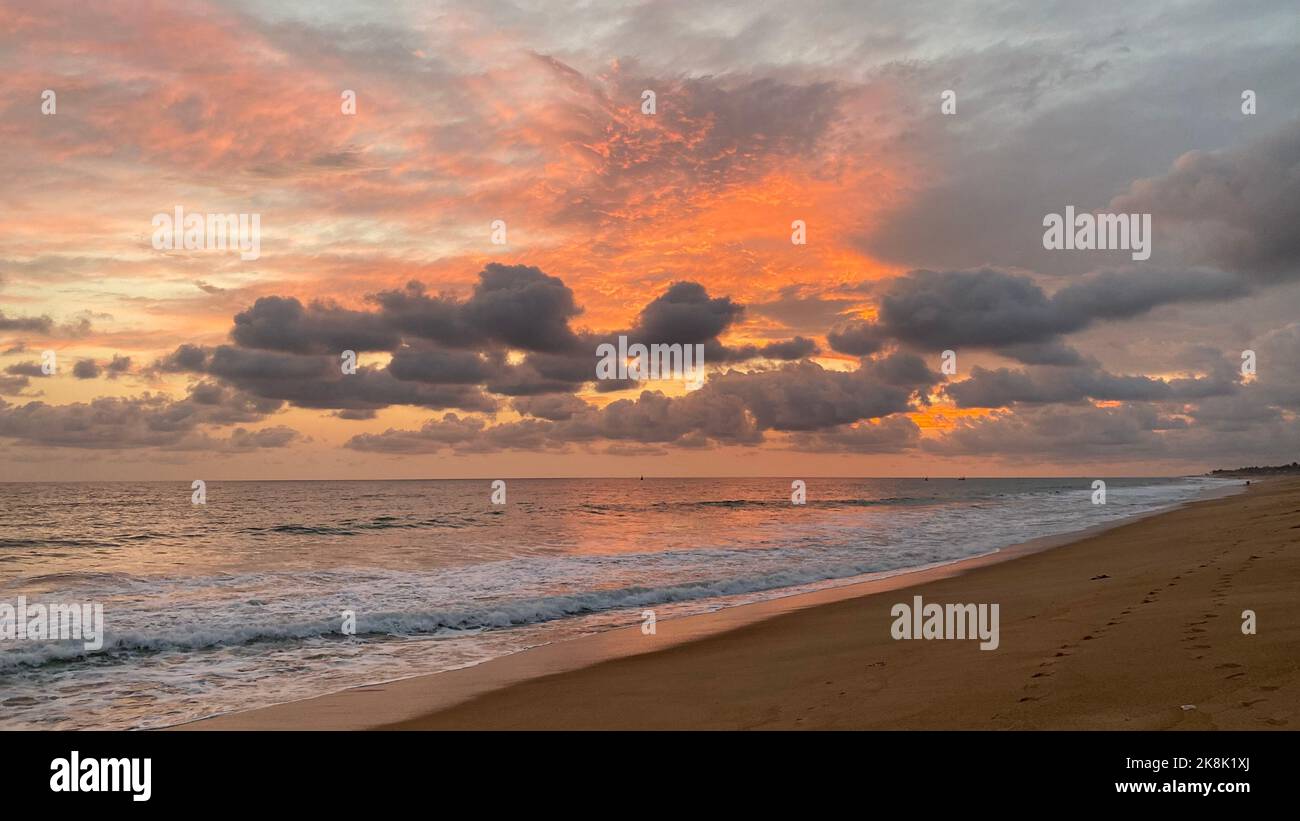 A miraculous sunset at the sandy beach with a track of people Stock ...