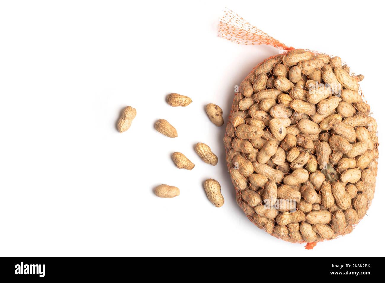 A top view of peanuts stored in a mesh bag cut out on a white ...