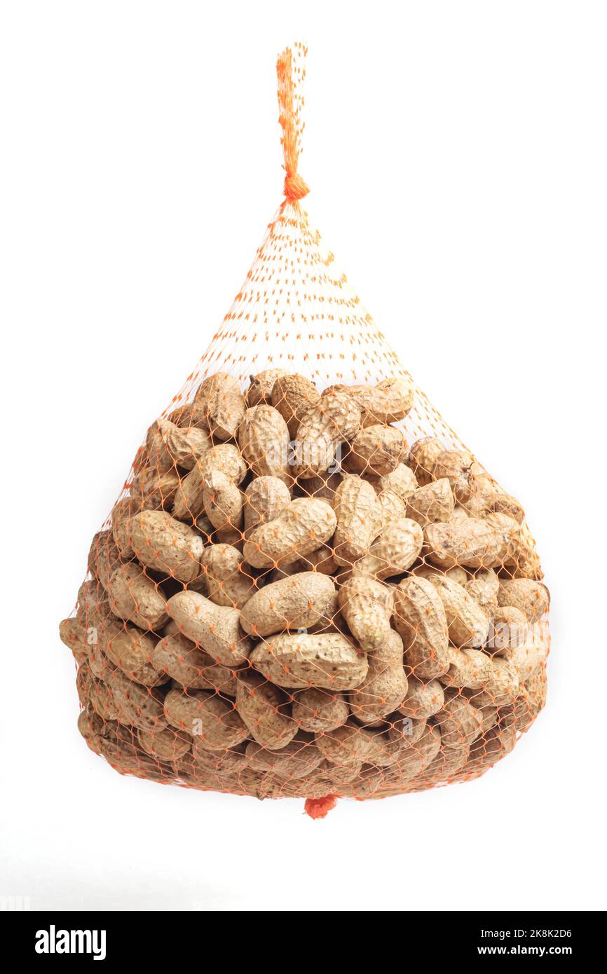 A vertical view of a mesh bag full of shelled peanuts hanging on a ...