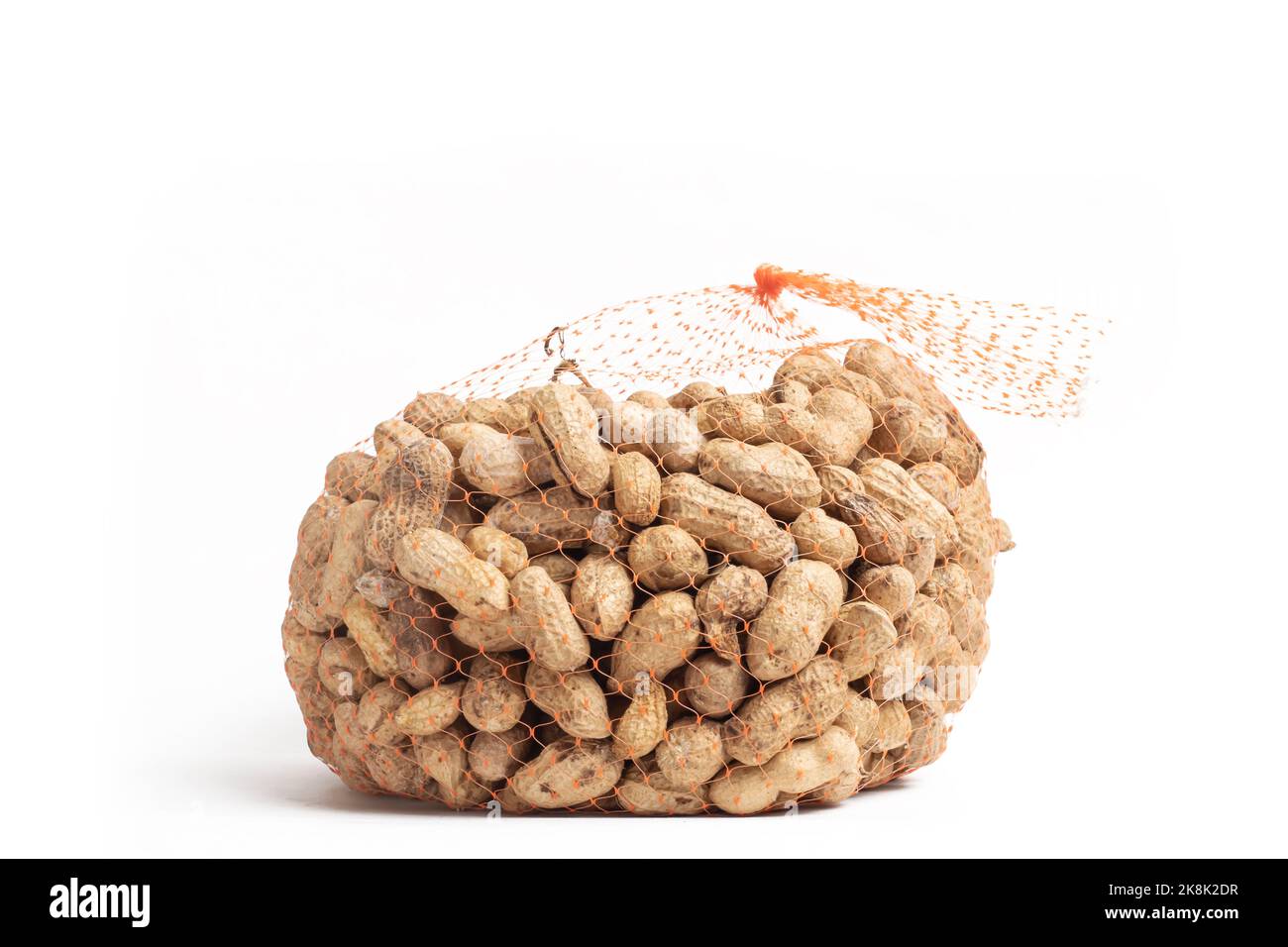 A mesh bag full of shelled peanuts on a white background Stock Photo ...