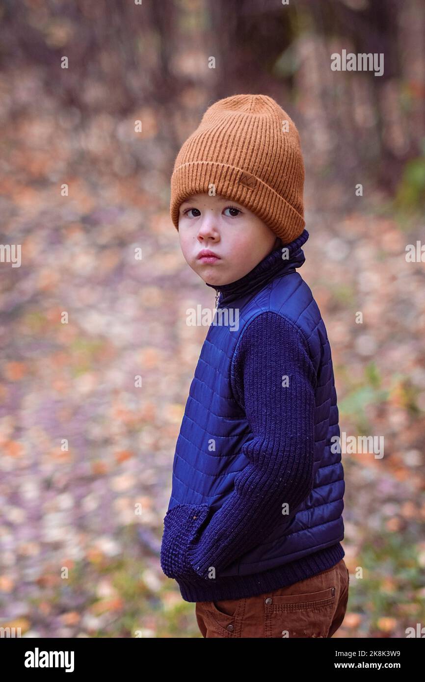 sad little boy in autumn park walking Stock Photo - Alamy