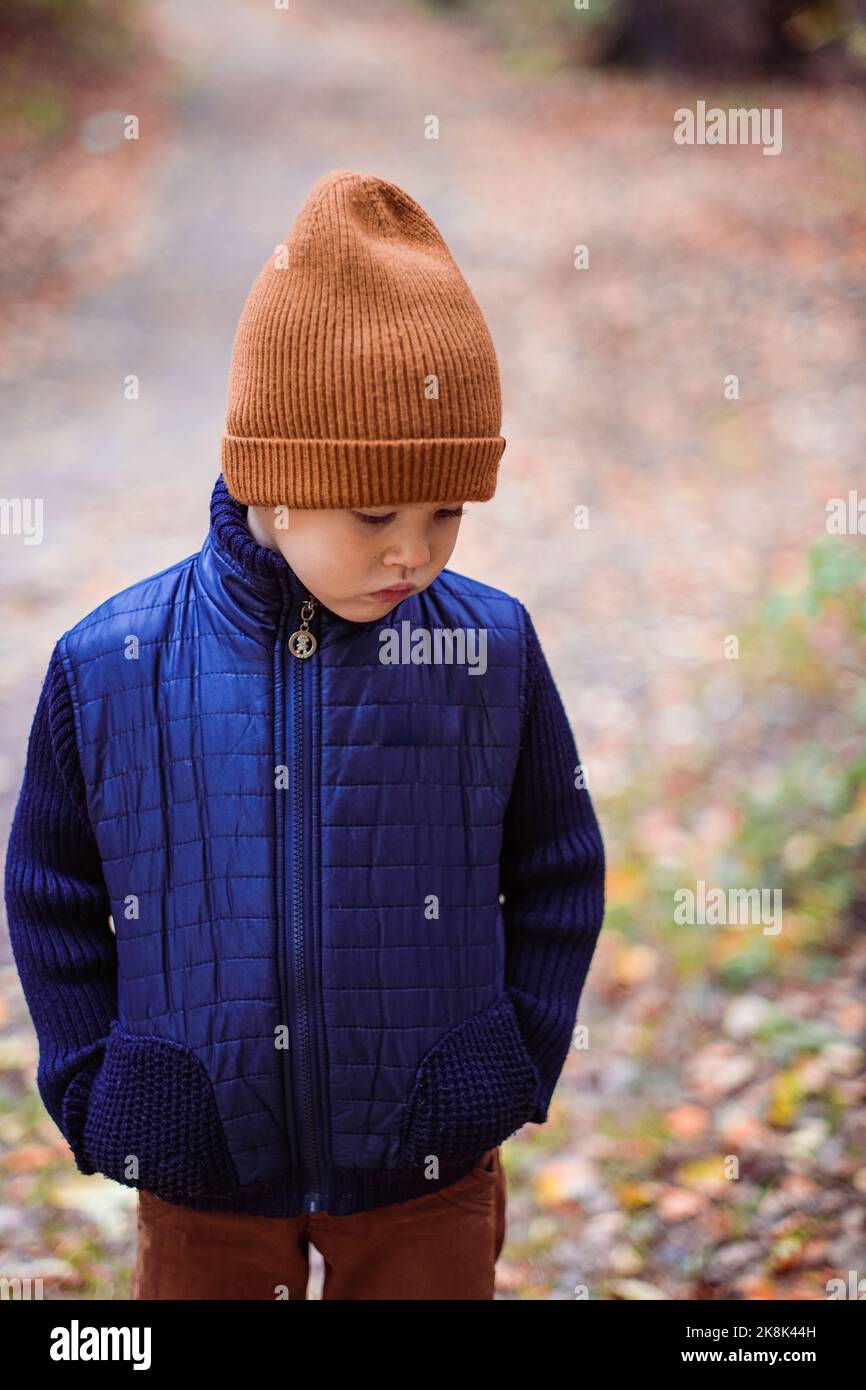 sad little boy in autumn park walking Stock Photo - Alamy