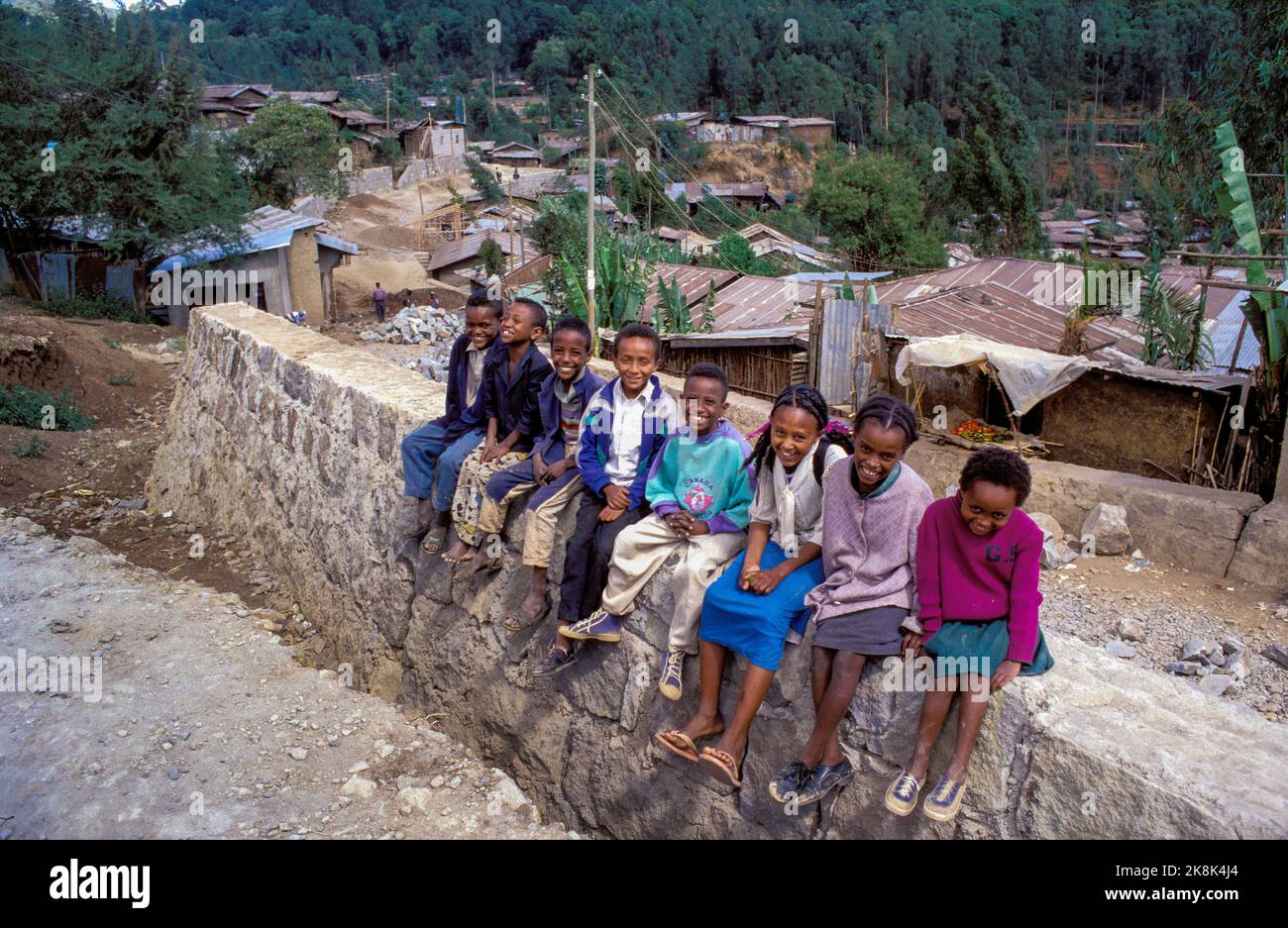 Ethiopia, Tigray; Children sitting on a brick wall in a village Stock ...