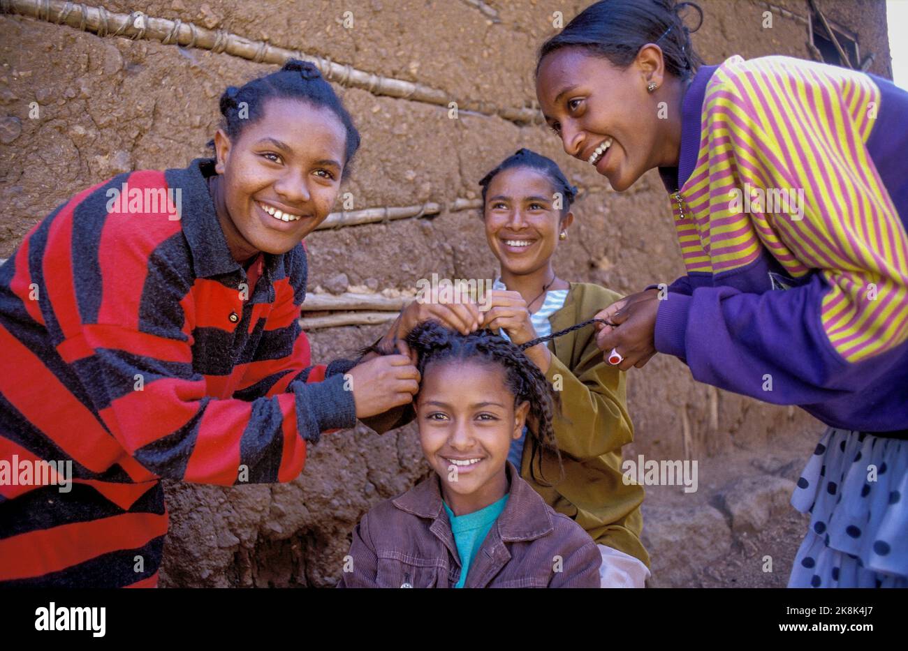 Ethiopia, Tigray; Four sisters have fun braiding one of the girls' hair ...