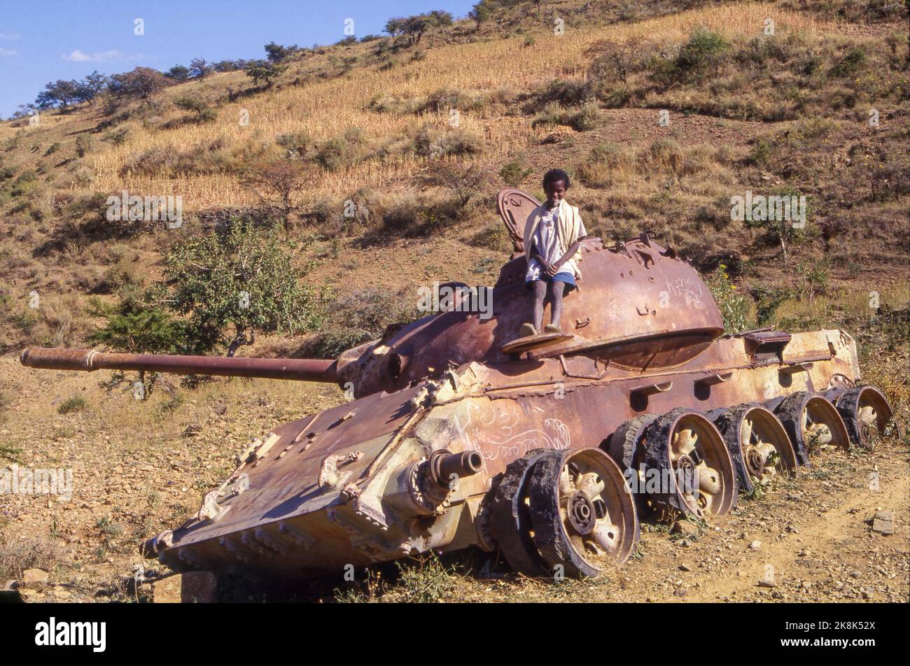Ethiopia, Tigray; boy is sitting on an abandond ramshackled armoured ...