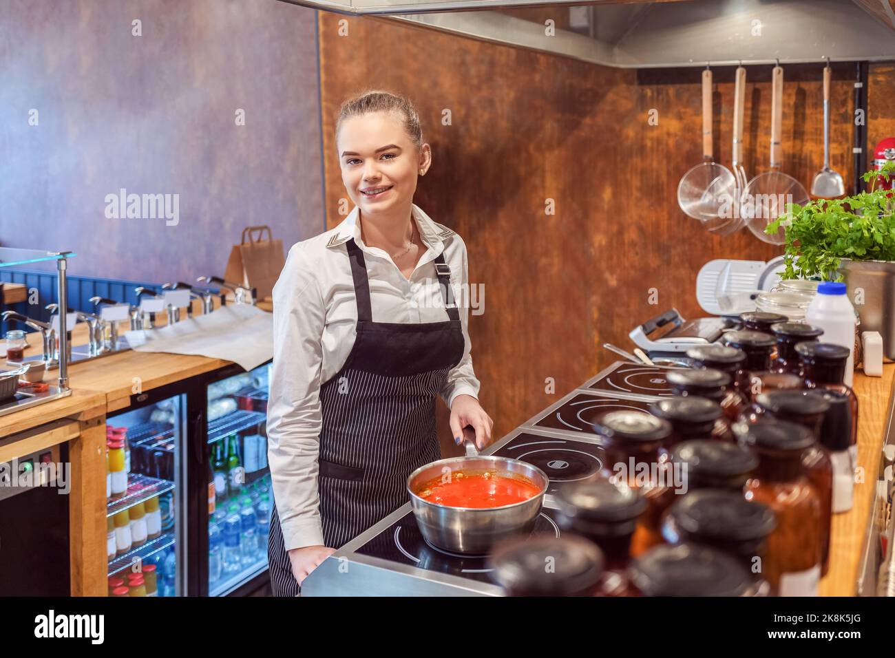 Chef woman prepare traditional pasta sauce on restaurant kitchen stove ...