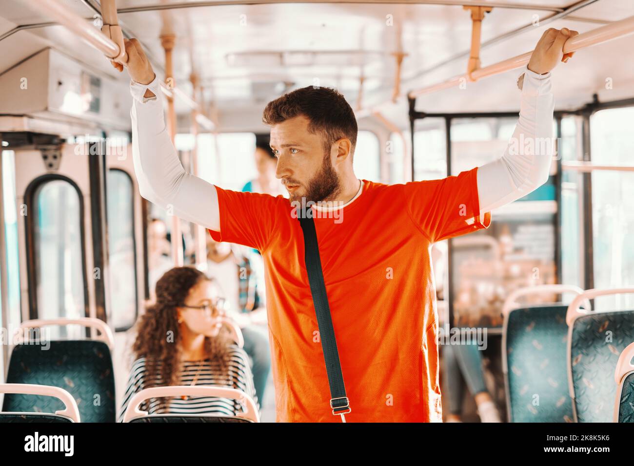 Man holding to a handrails in a bus, looking trough window Stock Photo ...