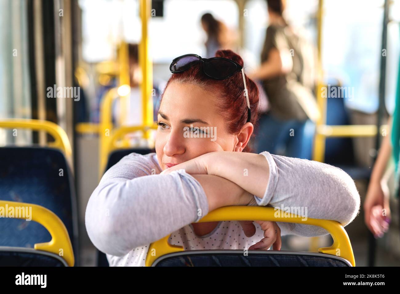 Bored middle-aged Caucasian woman sitting in city bus, leaning on seat ...