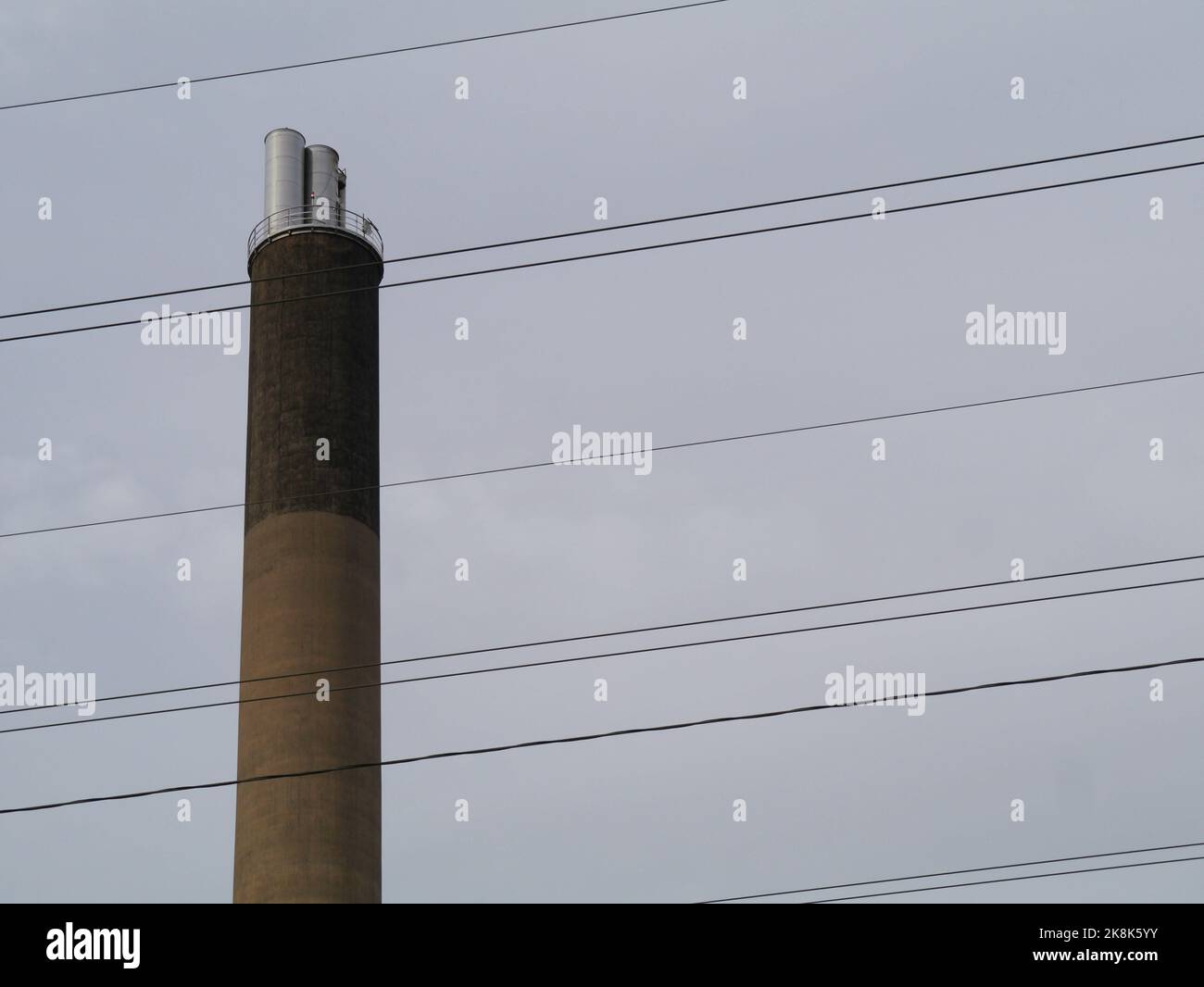 low angle of electric cables in front of industrial chimney Stock Photo ...