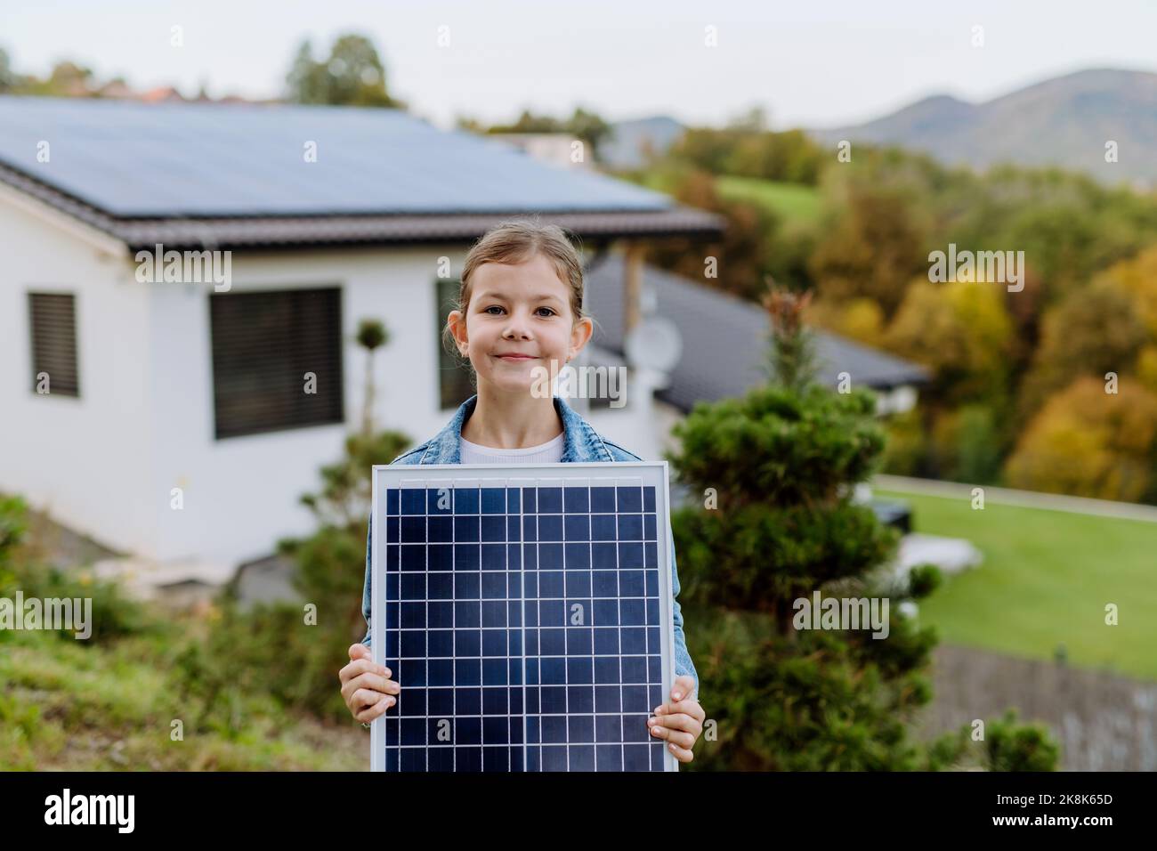 Little girl holding photovoltaics solar panel. Alternative energy ...