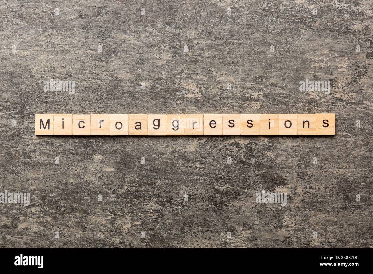 Microaggressions word written on wood block. Microaggressions text on ...