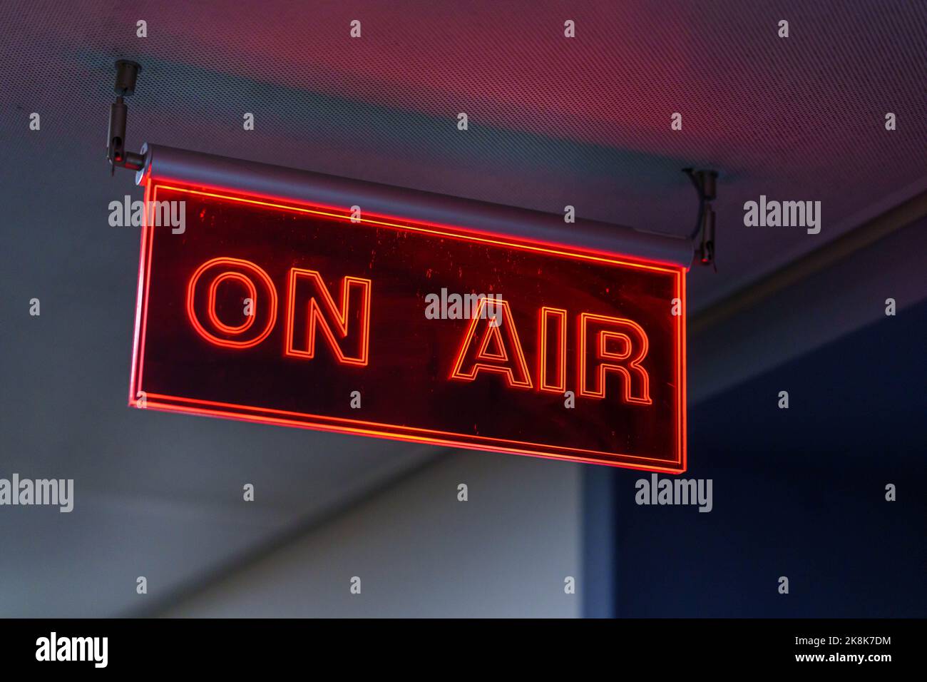 A close-up shot of an illuminated neon signboard "on air" hanging from ...