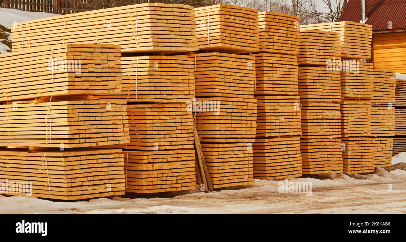 Stack of fresh pine boards in a sawmill warehouse. Harvesting, sale of ...
