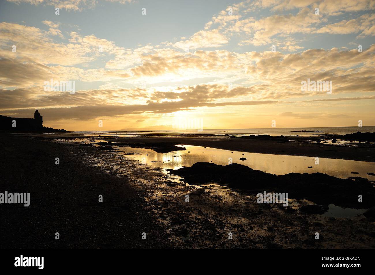 A sunset at Ayr Beach, Scotland and ruins of Greenan Castle Stock Photo ...