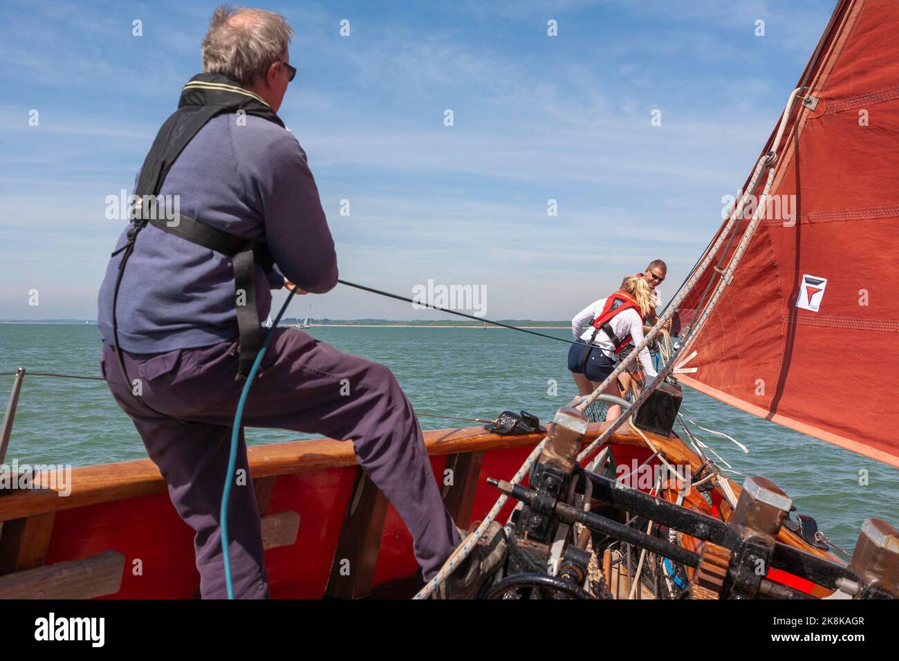 Crew working out on the bowsprit aboard the traditional gaff cutter ...