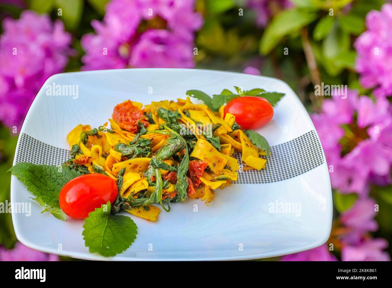 Delicious pasta with vegetables in the blurred background of purple ...