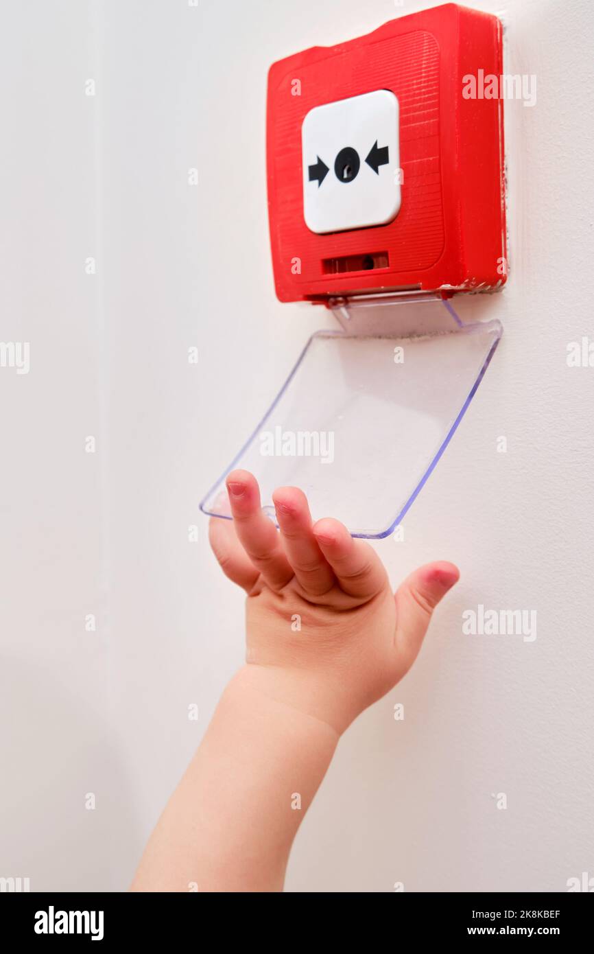 Toddler baby reaches for the fire alarm, child s hand turns on the call ...
