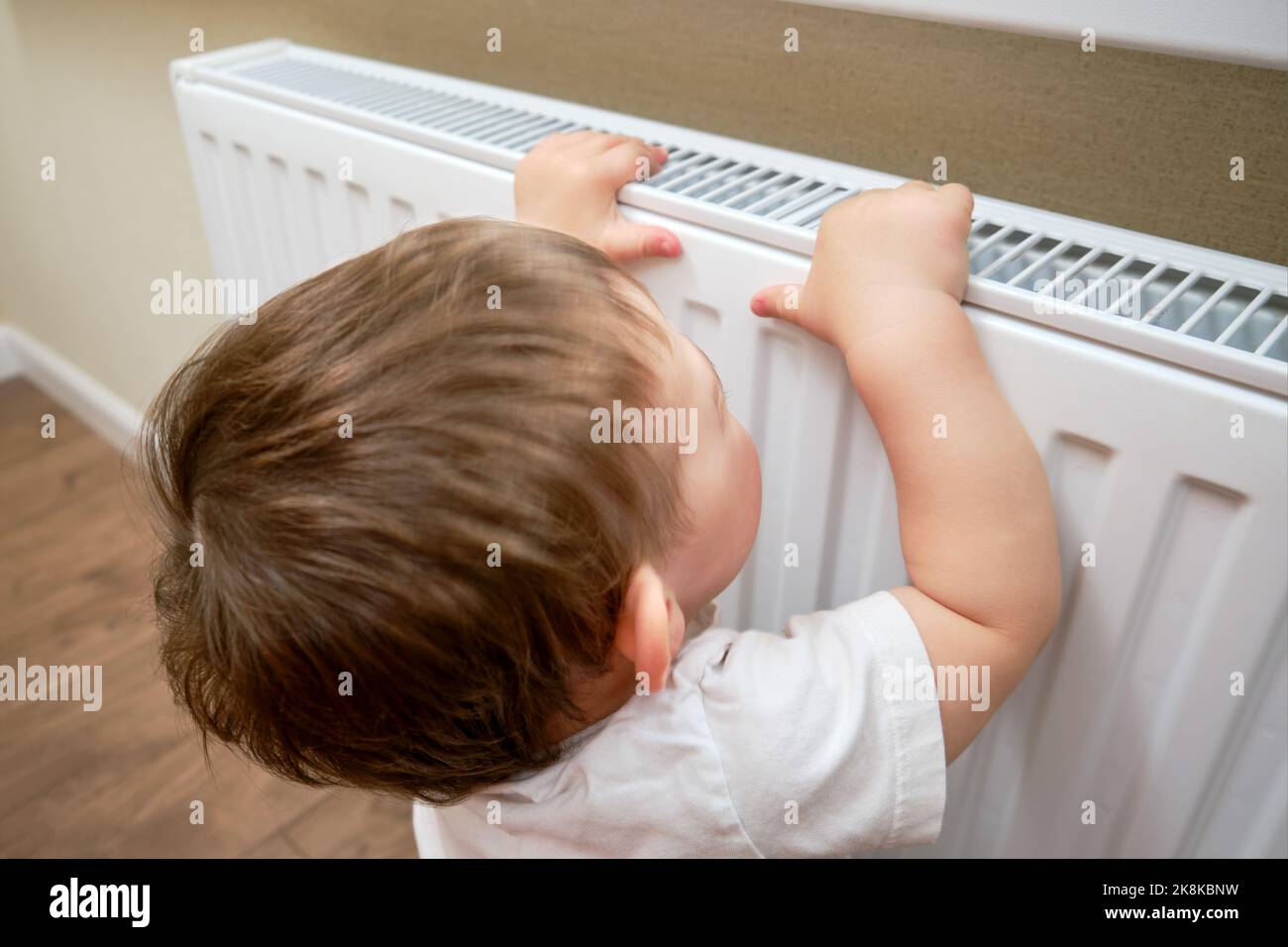 Toddler baby holding on to the radiator, child hand on the heating ...