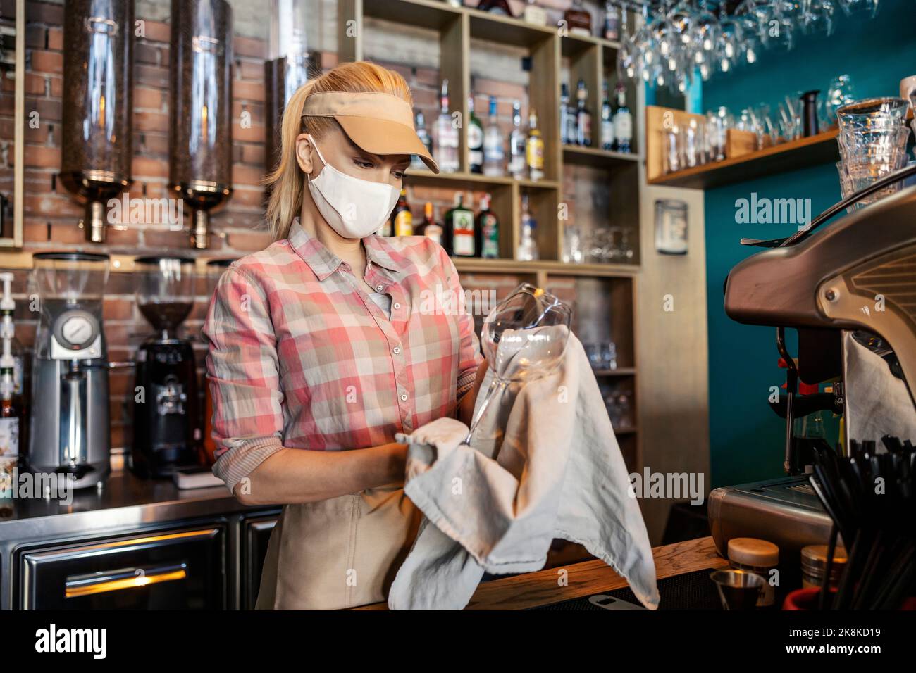 Cleaning the bar in the restaurant. An adult blonde woman in a waiter's ...
