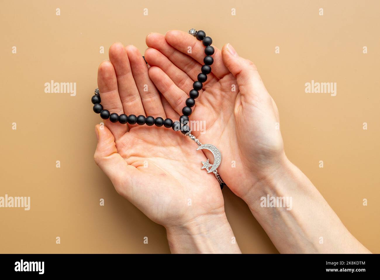 Islamic prayer concept. Hands holding Muslim rosary with silver crescent moon Stock Photo - Alamy