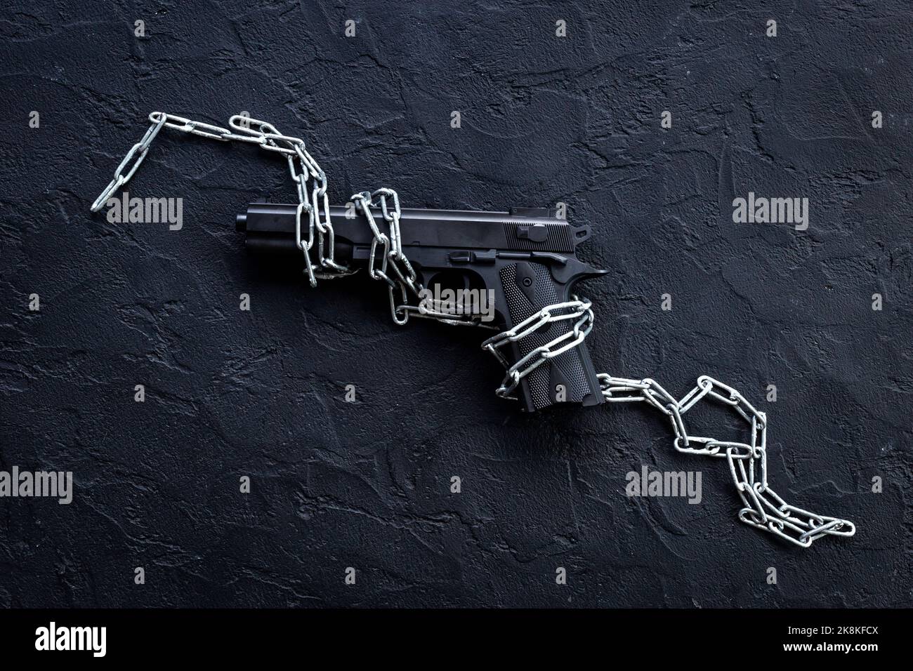 Hand gun weapon in chains. Ban on carrying weapons gun law concept ...