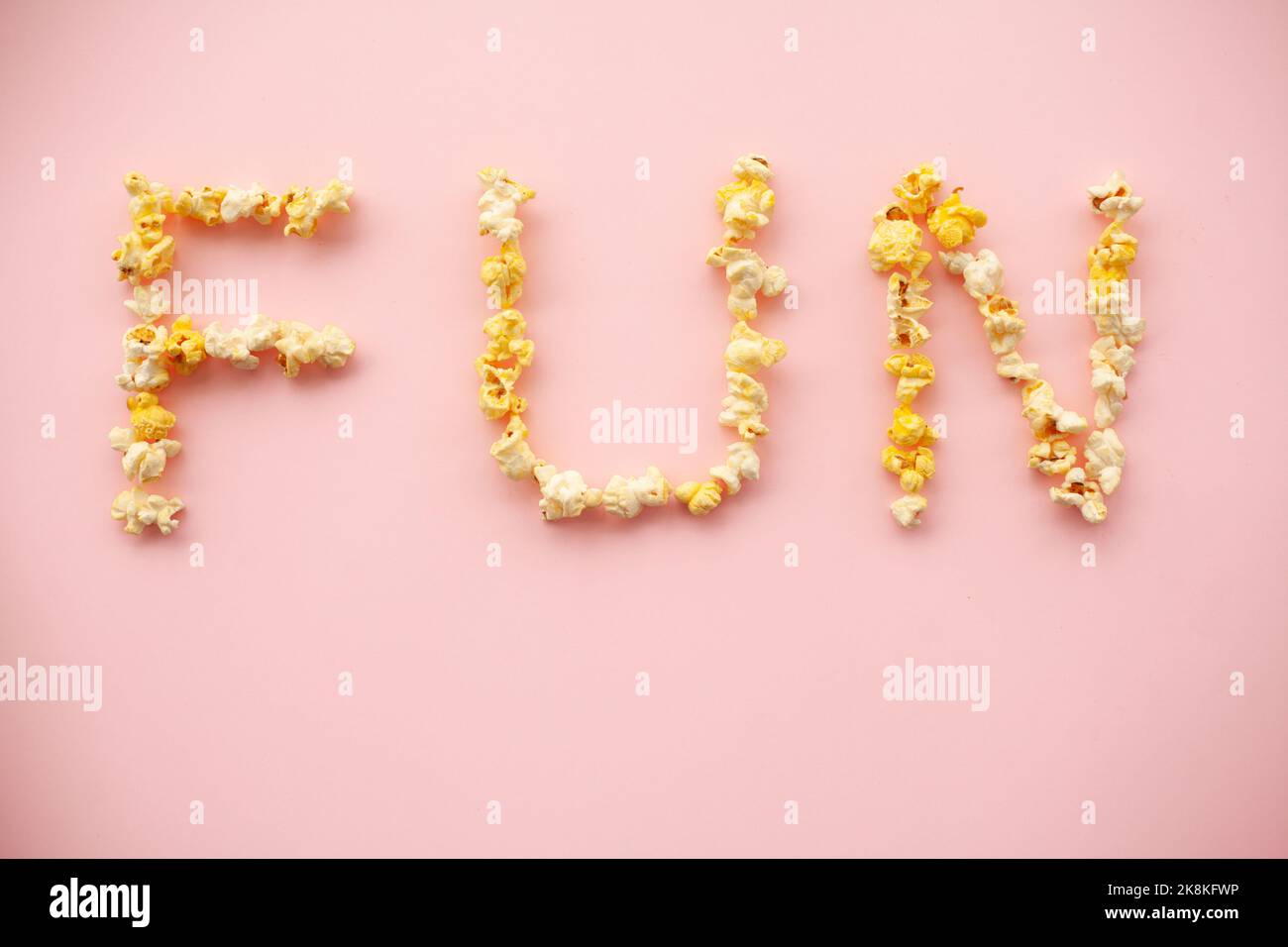 Food. Word of Fun. Popcorn bucket. Delicious Popcorn on Pink Background ...