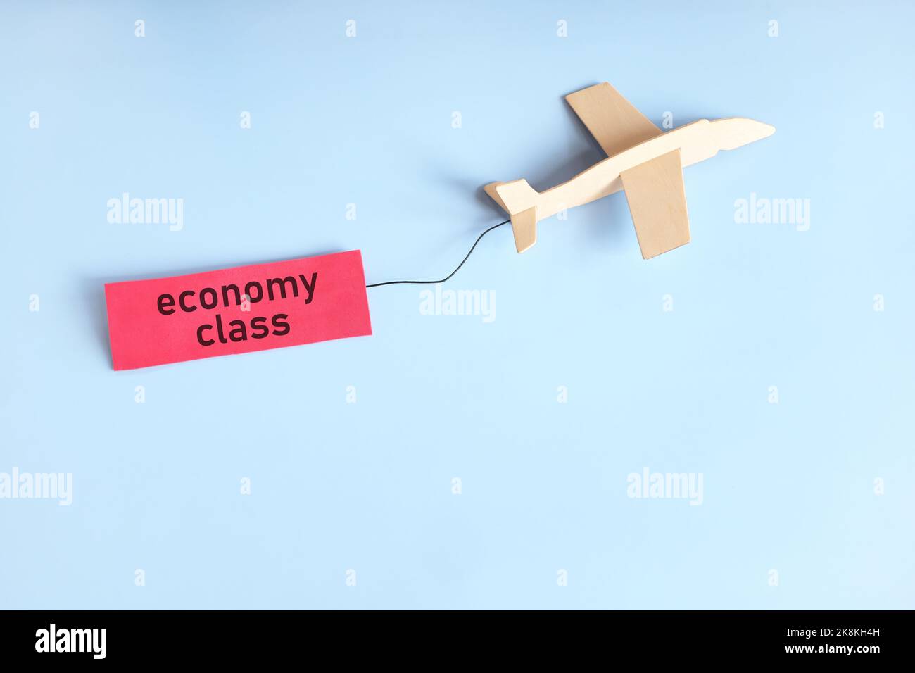 Fly economy class ticket concept. Commercial airplane wooden model with ...