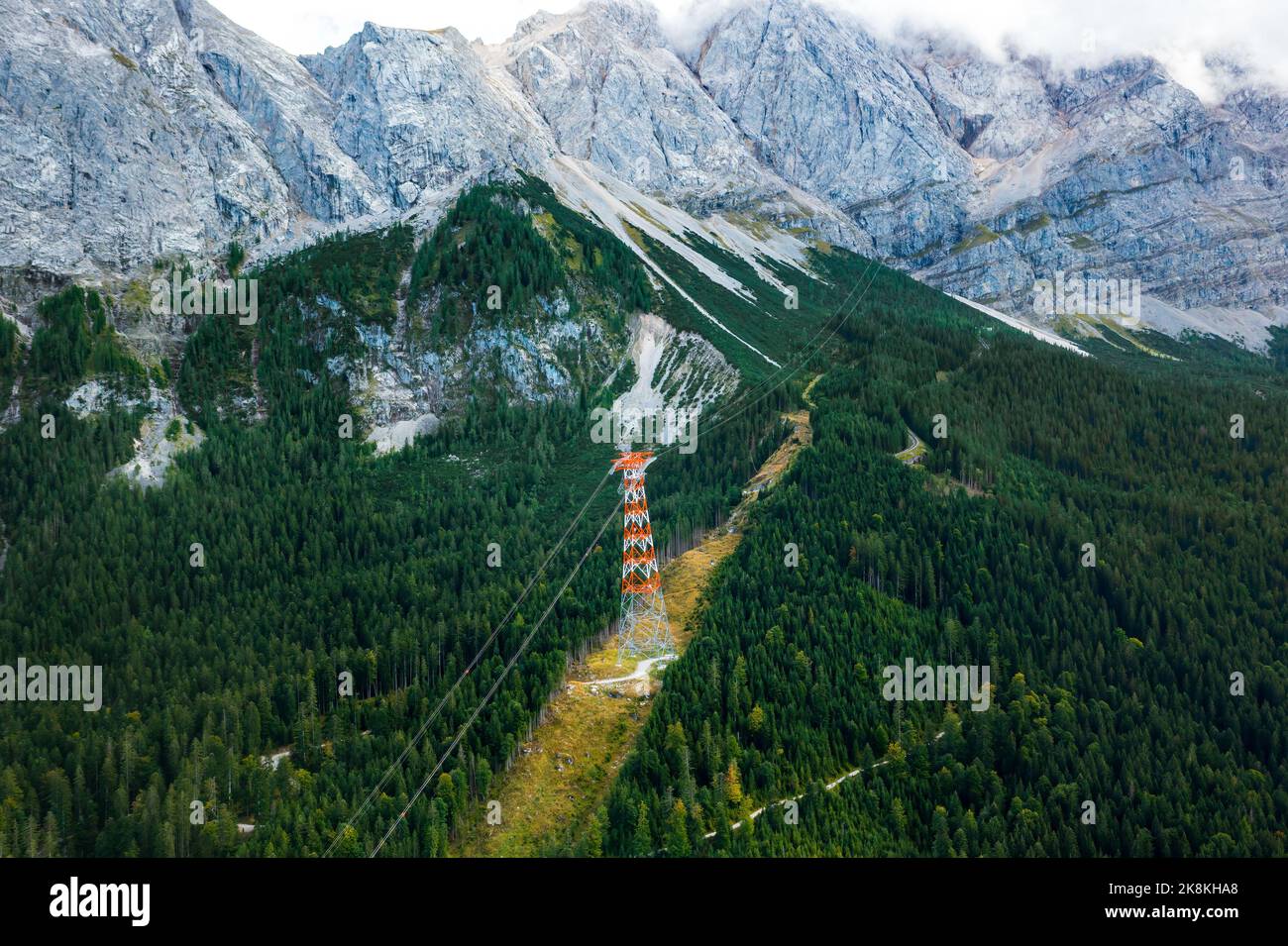 High voltage electric transmission tower in the mountains surrounded by ...