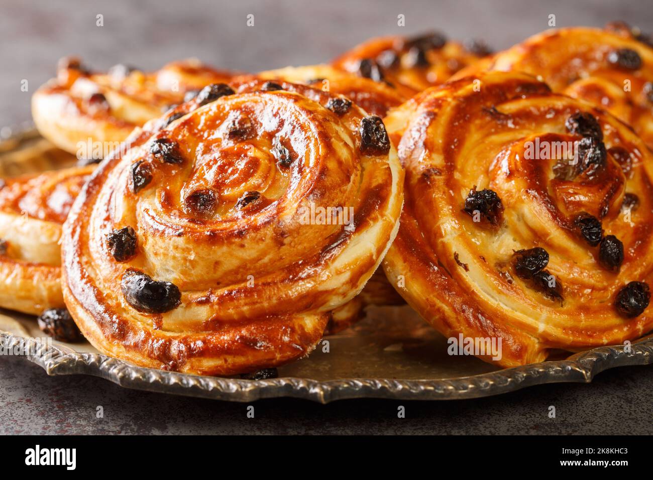 Delicious pain aux raisins spiral buns with raisins and custard close ...