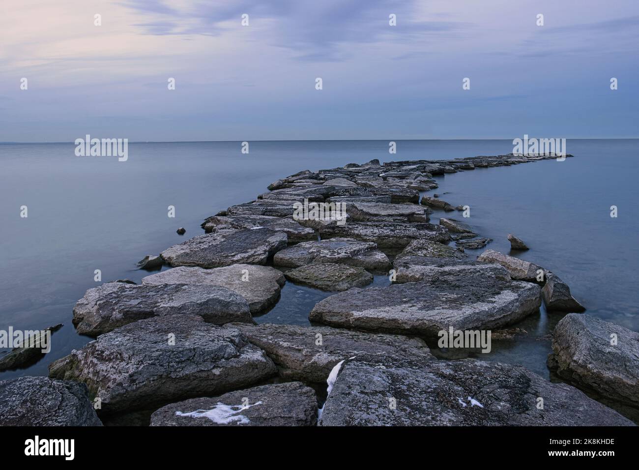 An aerial view of rocky path surrounded by water in sea Stock Photo - Alamy