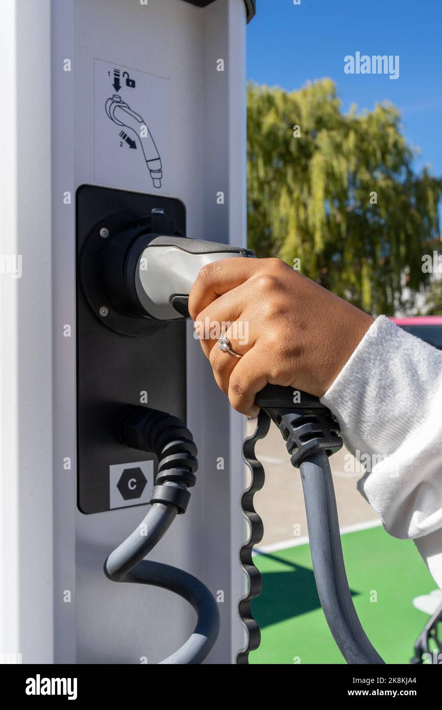 woman using an electric charging point for her vehicle Stock Photo - Alamy