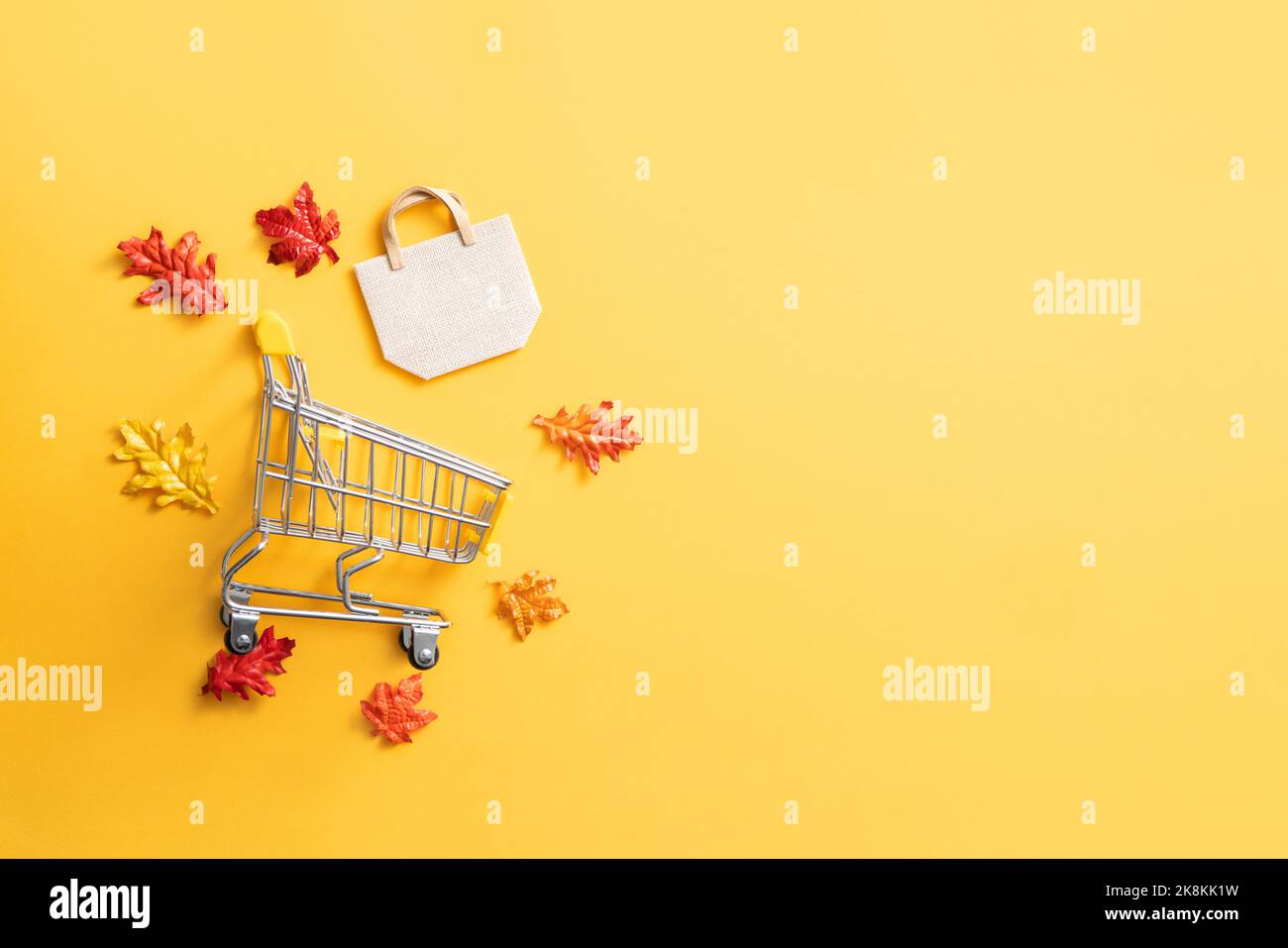 Autumn shopping design concept with shopping cart and maple leaves on ...