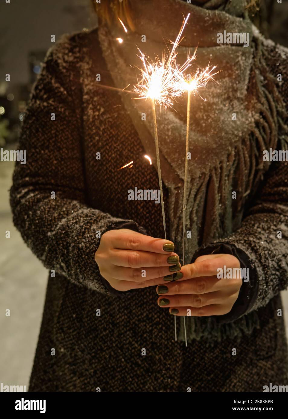 New year party burning sparkler closeup in female hand on black ...