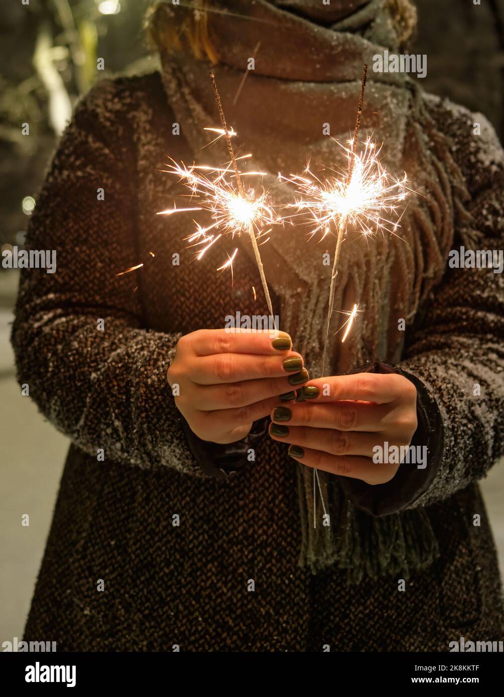New year party burning sparkler closeup in female hand on black ...