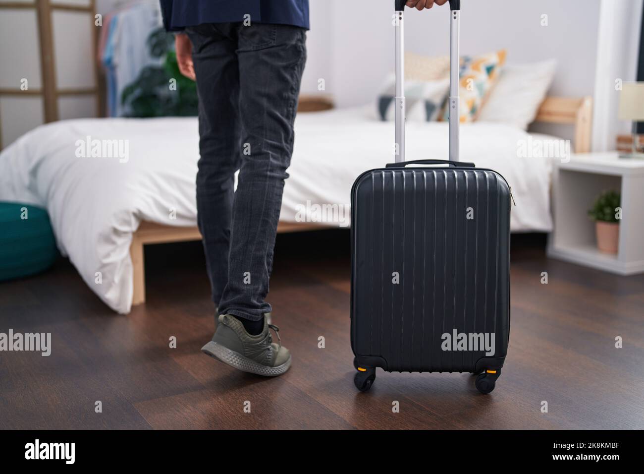 Young hispanic man business worker holding suitcase walking at hotel ...