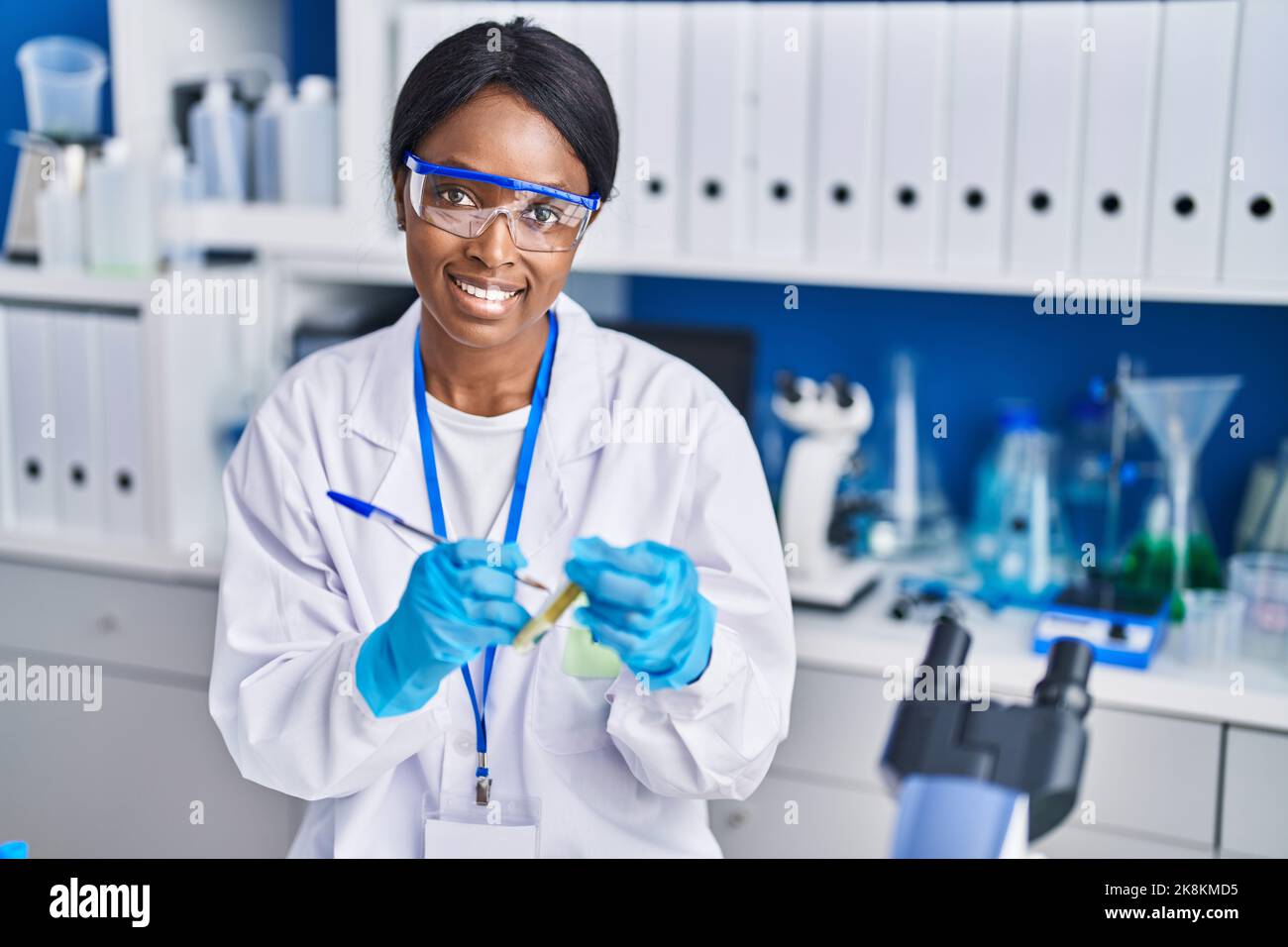 Young african american woman scientist smiling confident writing on ...