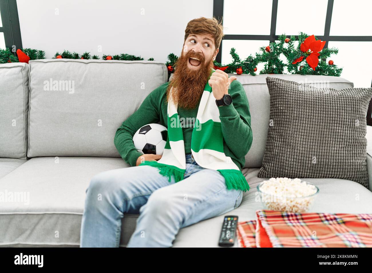 Redhead man with long beard football hooligan holding ball sitting on ...