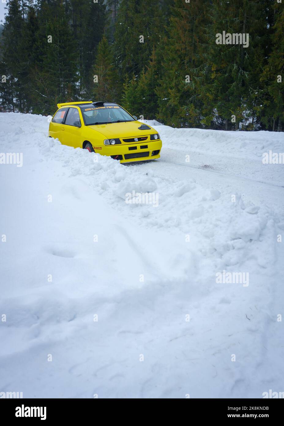 A vertical of a rally car on Levoca Rally driving on snow in a forest ...