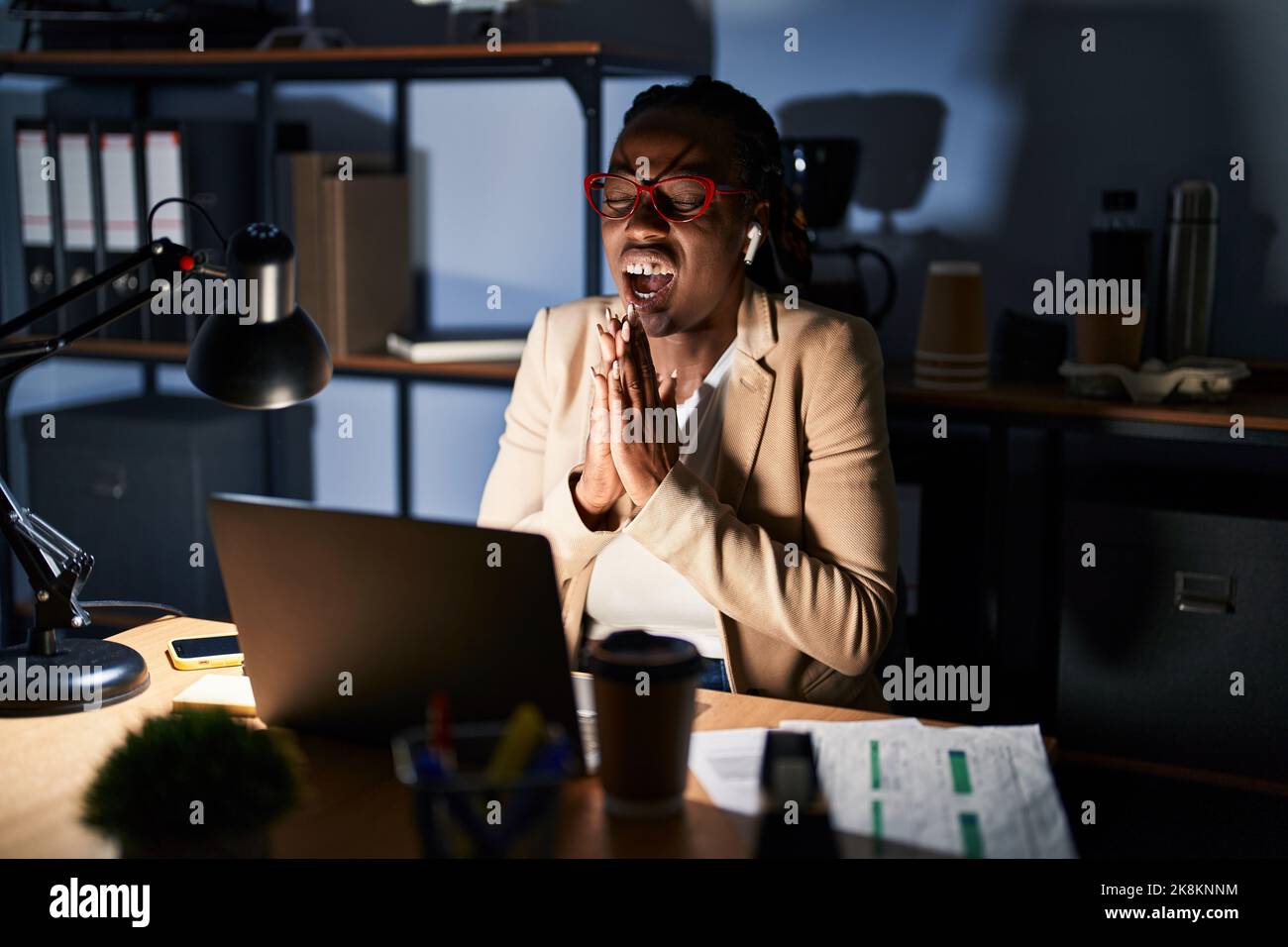 Beautiful black woman working at the office at night begging and ...