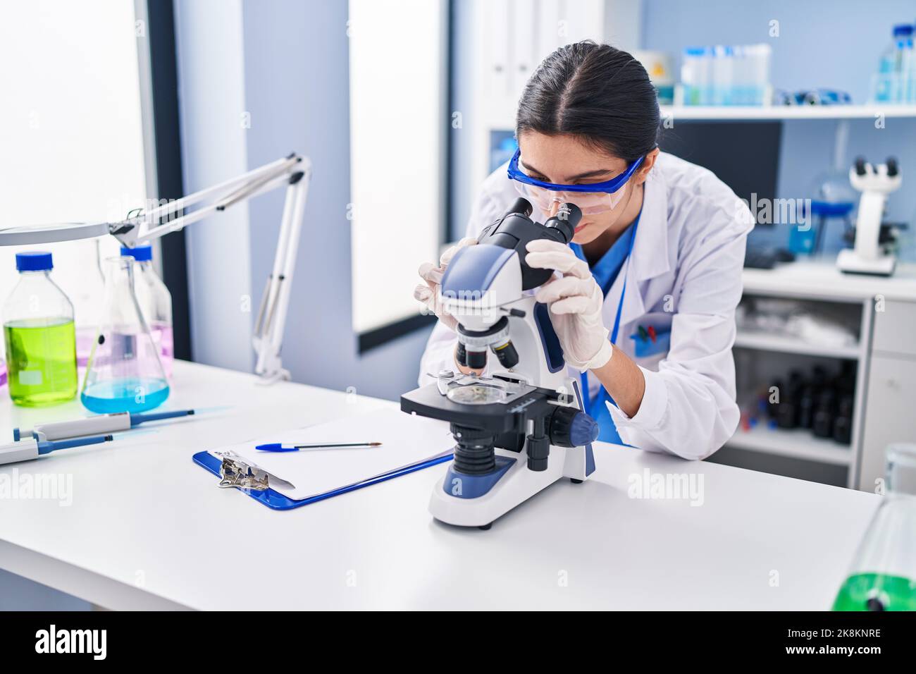 Young beautiful hispanic woman scientist using microscope at laboratory Stock Photo - Alamy