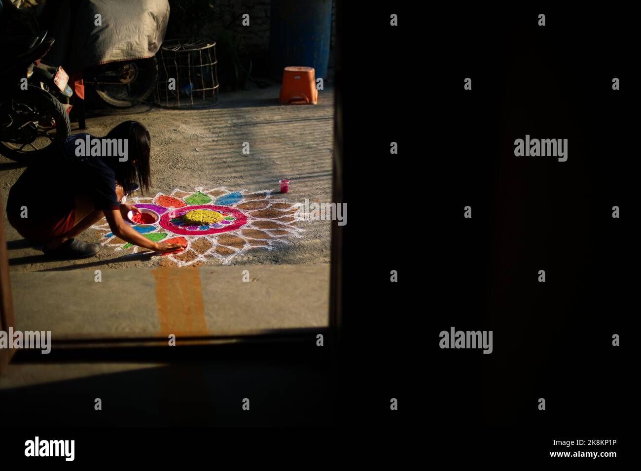Nepal. 24th Oct, 2022. Girl making Rangoli li infornt of her house ...