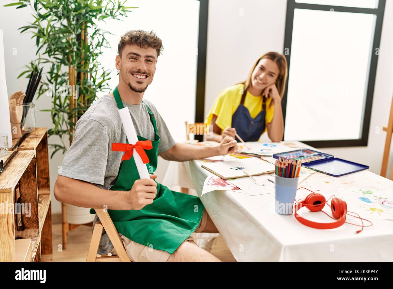 Young hispanic artist couple smiling happy drawing at art studio. Man ...