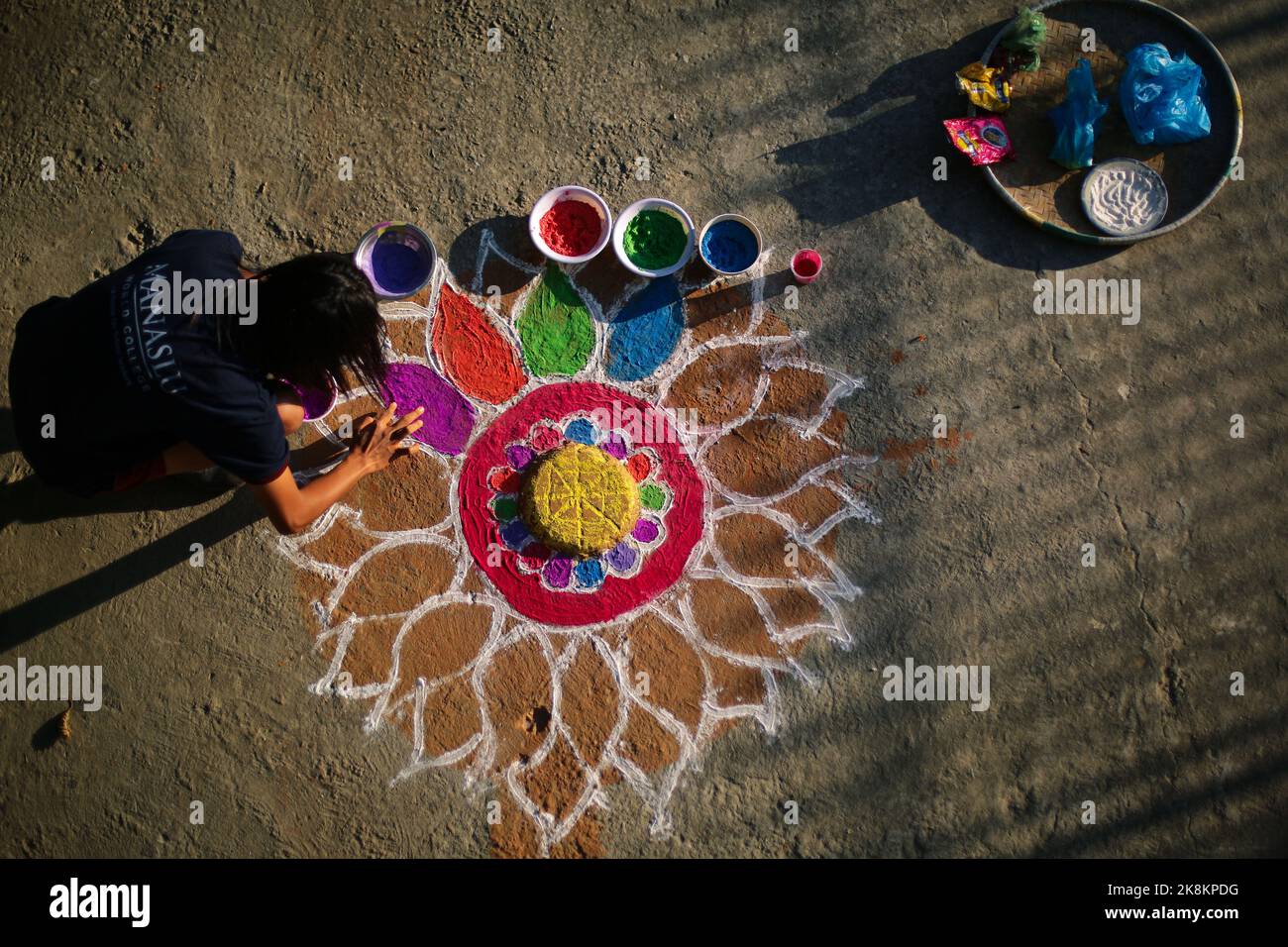Nepal. 24th Oct, 2022. Girl making Rangoli li infornt of her house ...