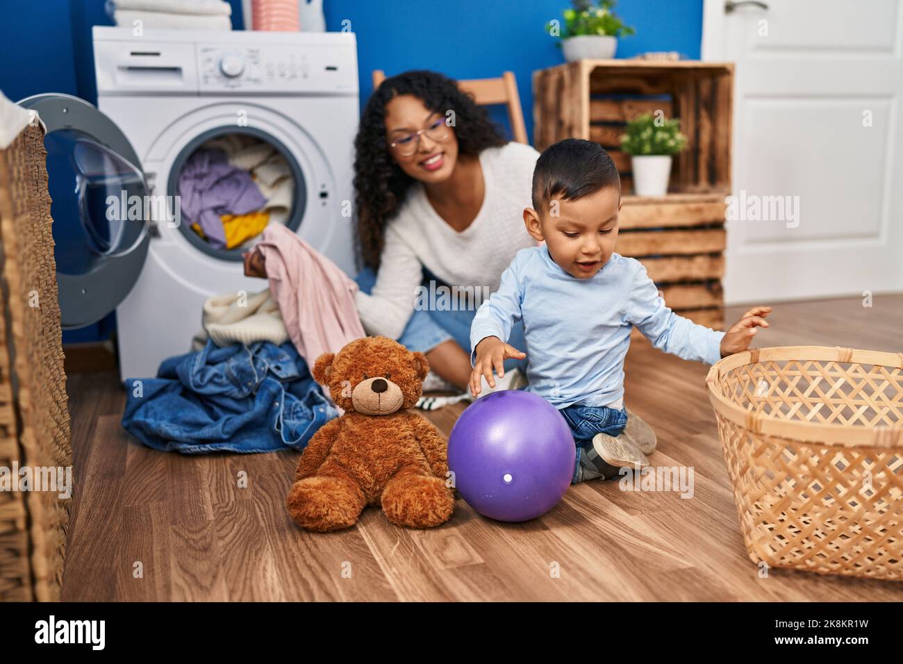 Mother and son smiling confident washing clothes at laundry room Stock ...