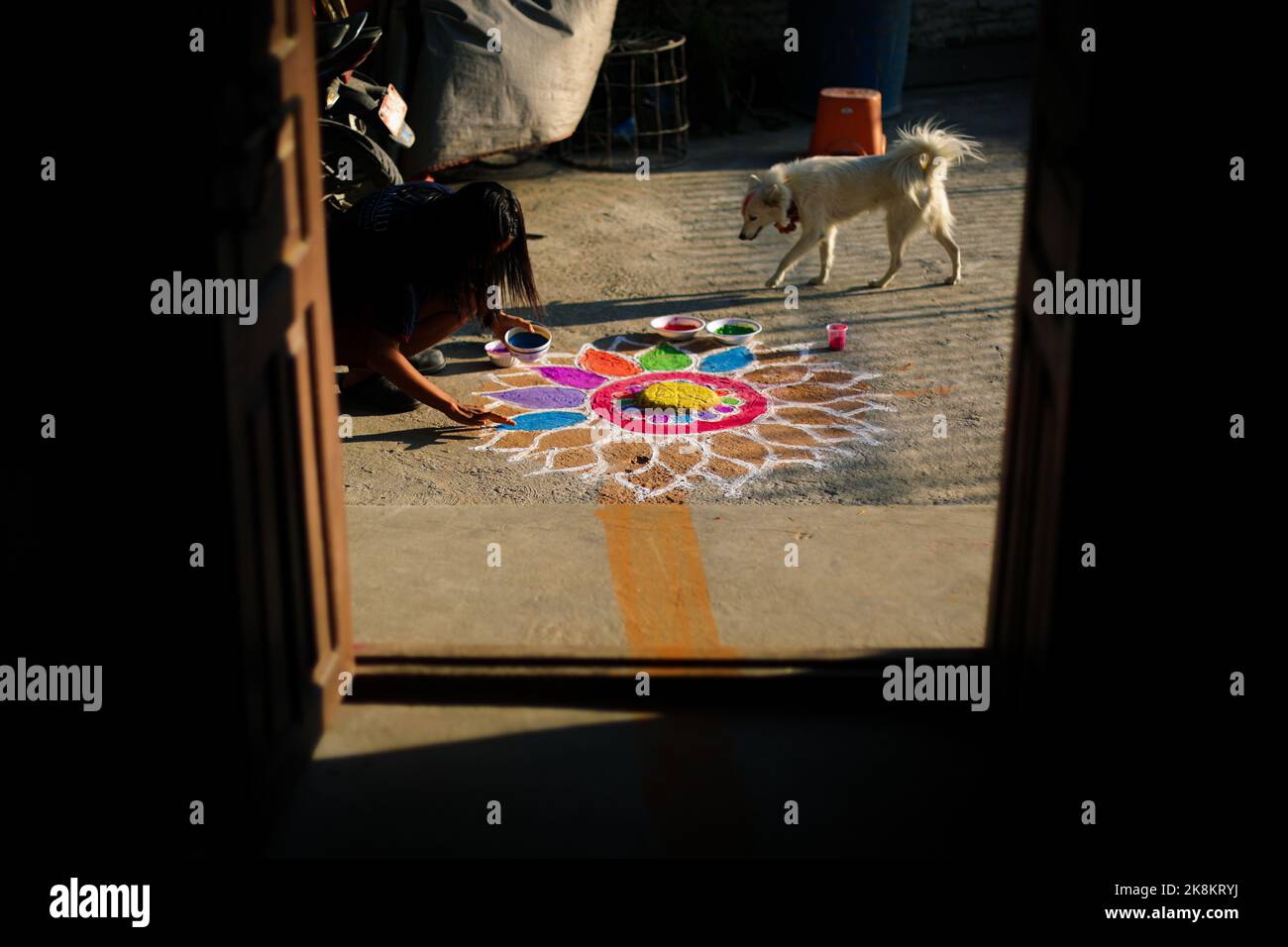 Nepal. 24th Oct, 2022. Girl making Rangoli li infornt of her house ...