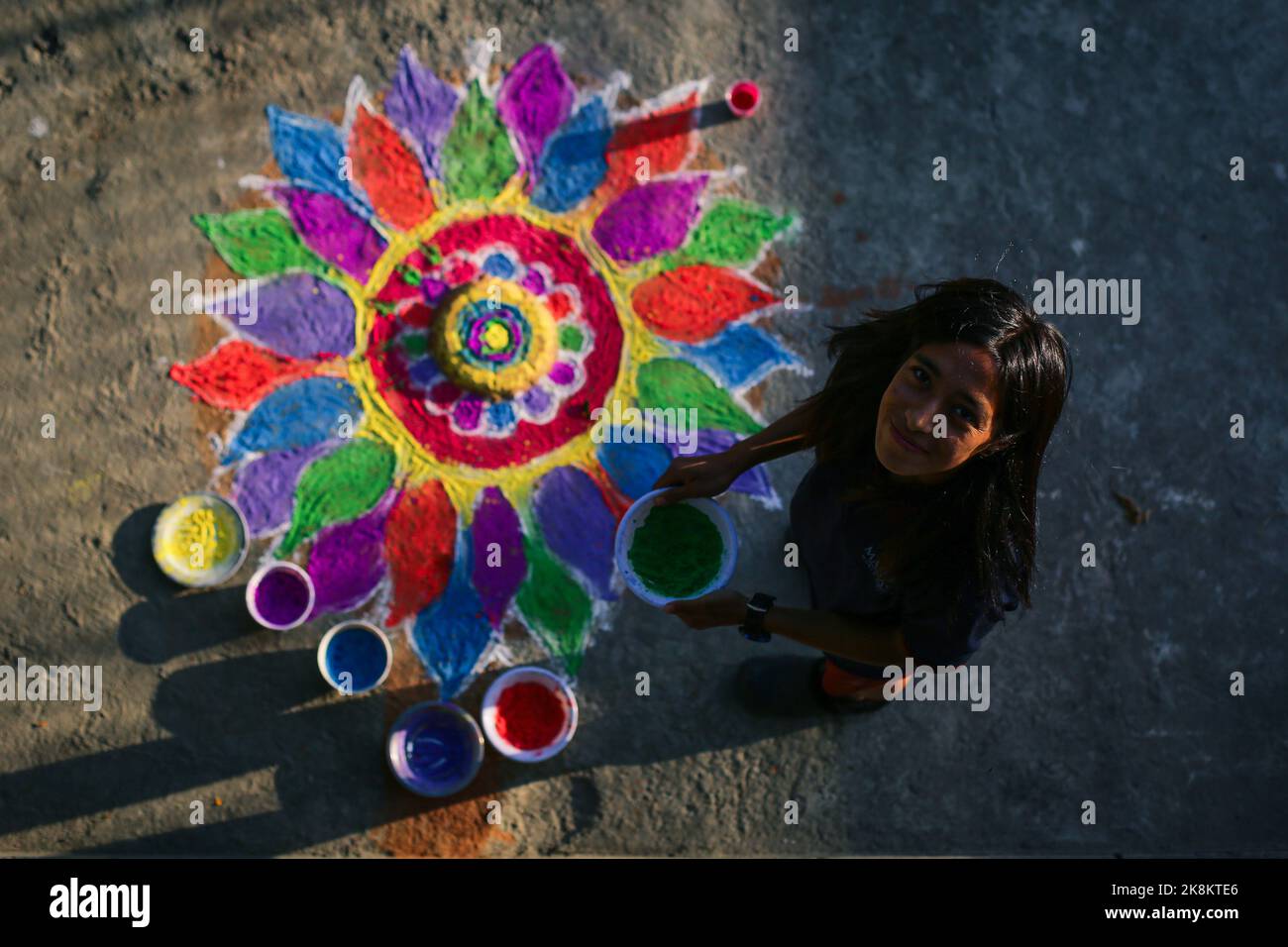 Nepal. 24th Oct, 2022. Girl making Rangoli li infornt of her house ...